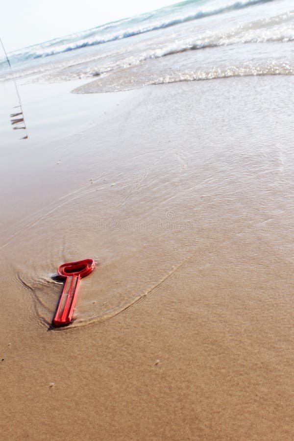 Red toy on the beach stock photo. Image of ocean, clear - 75488956