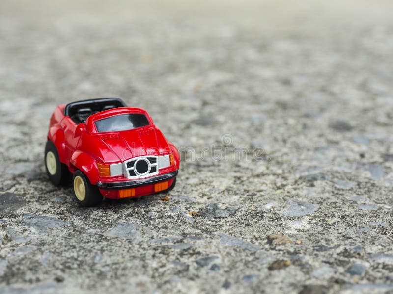 A Red Toy Car Park on Rough Cement Road. Stock Photo - Image of field ...