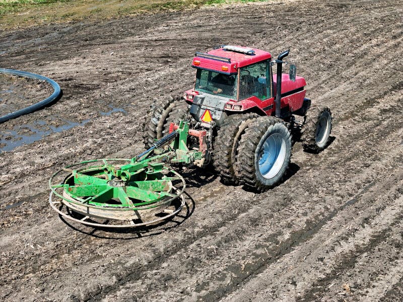 Red Tractor Using a Liquid Manure Hose Mover Getting Ready To Assist in ...