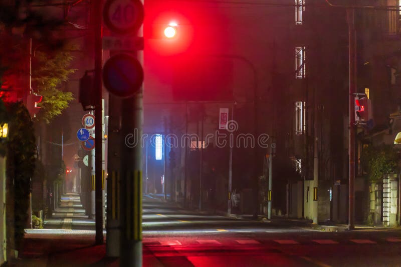 Red Traffic Light in Mist Over Empty Intersection and Sidewalk at Night ...