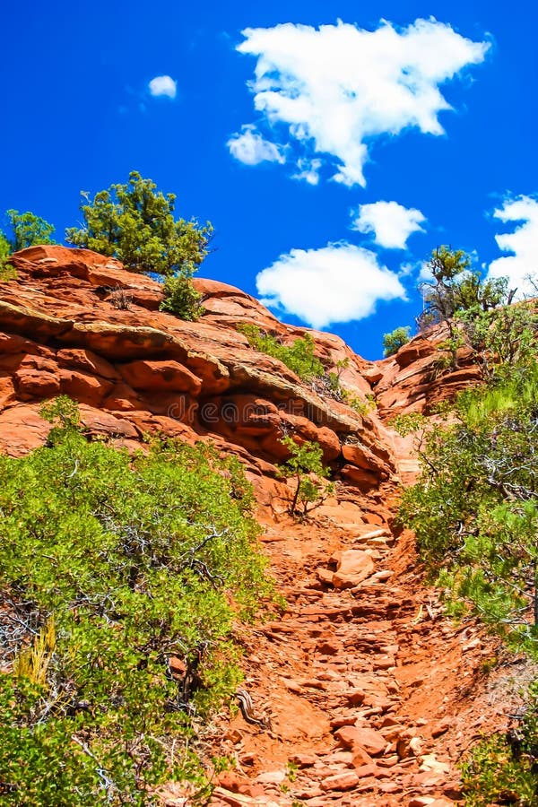 Red Trail Winding through Rocky Terrain and Lush Vegetation Stock Photo ...