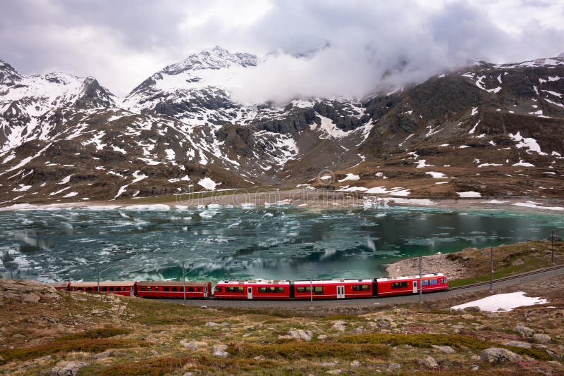 Red Train Going in Beautiful Landscape by Lake in Switzerland Stock ...