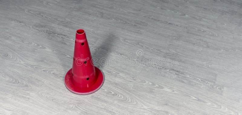 Red Training Cone Standing on Gray Laminate Floor Casting a Shadow ...