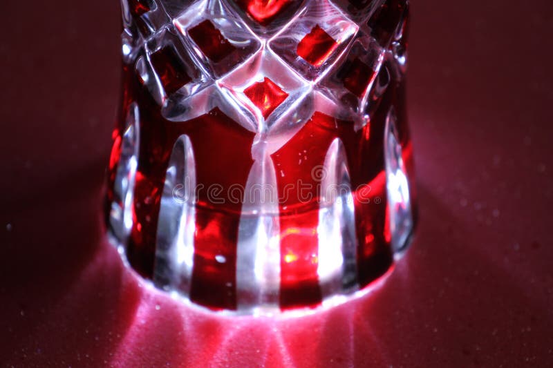 A Red and Transparent Glass Made Object is Sparking on a Dark Surface ...