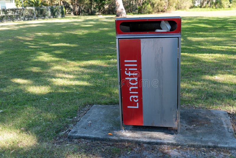 Red Trash Bin with Landfill Sign on it Outside in a Park Stock Image ...