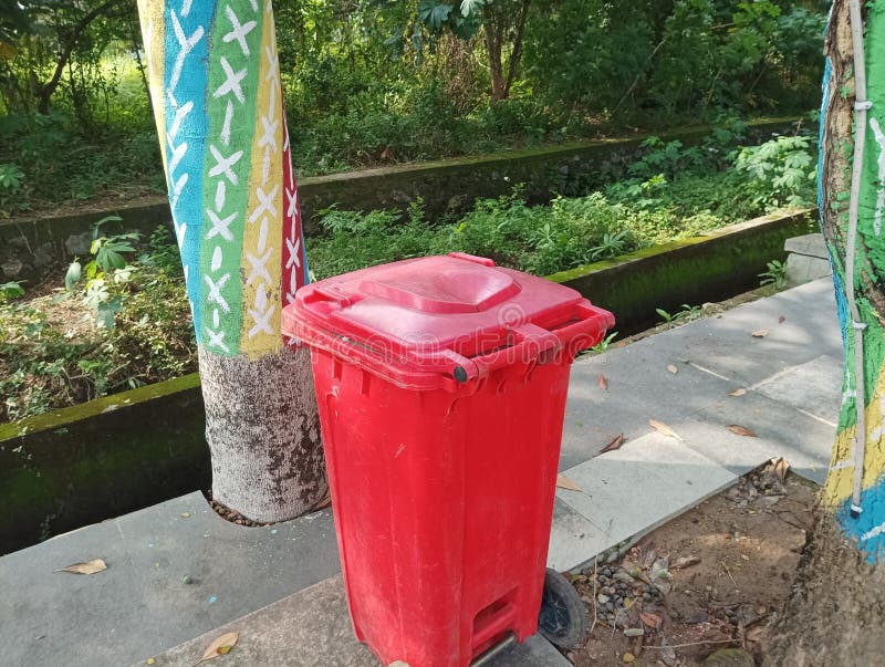 A Red Trash Can Located on the Sidewalk Stock Photo - Image of trash ...