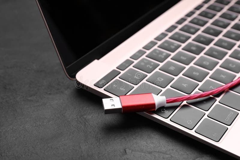 Red USB Cable and Laptop on Black Slate Table, Closeup Stock Image ...
