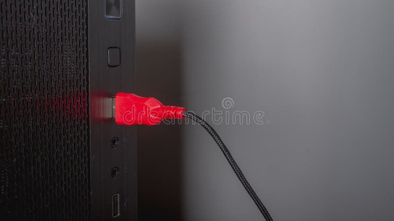 The Red USB Cord is Inserted into the USB Port of the Computer Stock ...