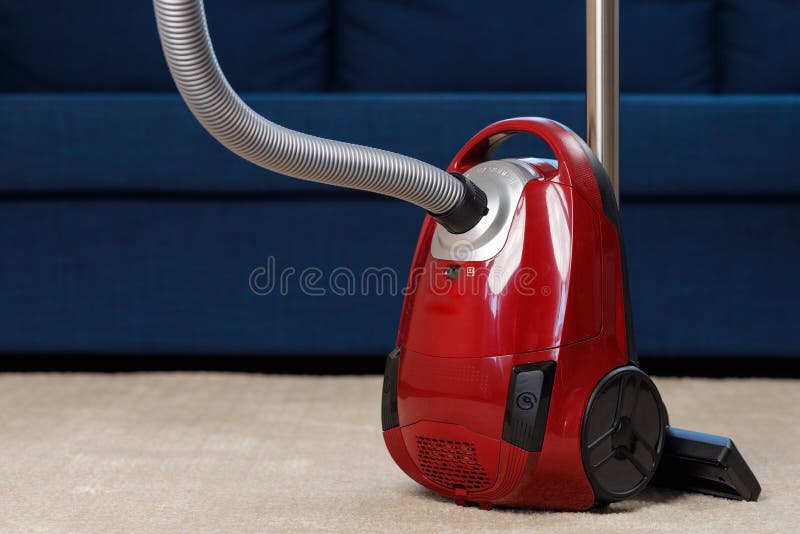 Red Vacuum Cleaner and Plastic Bucket with Liquid Detergents on Beige ...