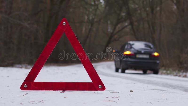 Red Warning Triangle on the Road in Front of a Broken Car with ...