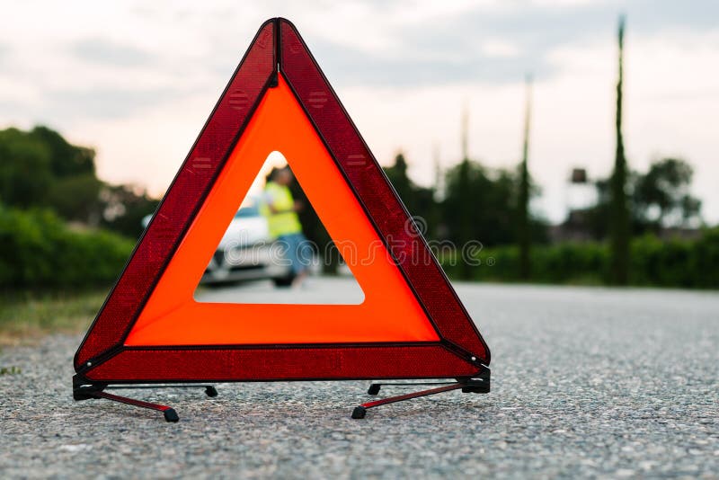 Red Warning Triangle and Young Man Using His Mobile Phone To Call His ...