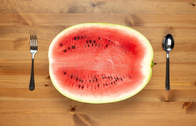 Red Watermelon Cut in Half, Top View, on Wooden Table, Fork and Spoon ...