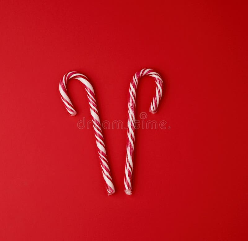 Red-white Candy Stick in Transparent Cellophane on a Red Background ...