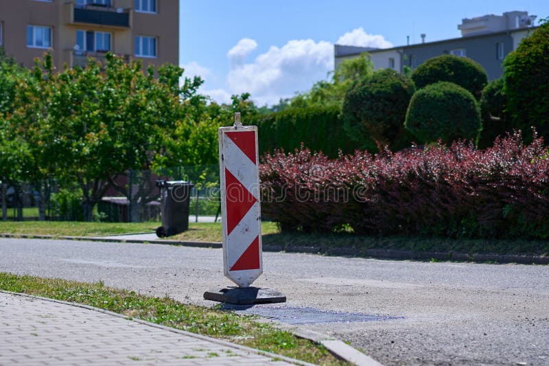 A Red and White Chevron-patterned Road Sign is Placed on a Paved Road ...