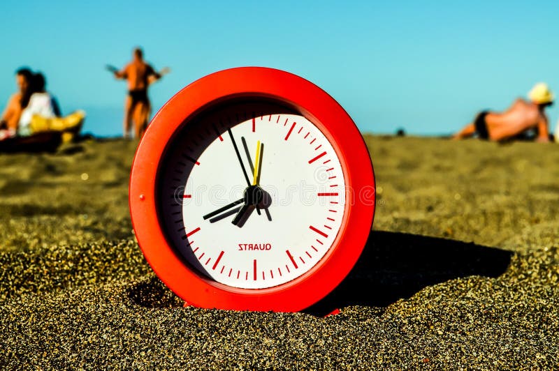 A Red and White Clock is Sitting on the Sand Stock Image - Image of ...