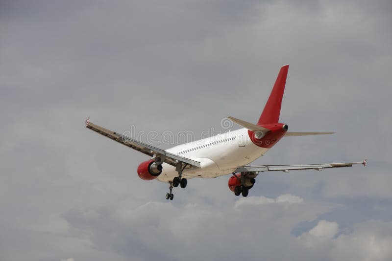 Red and White Commercial Plane Landing Stock Image - Image of tail ...