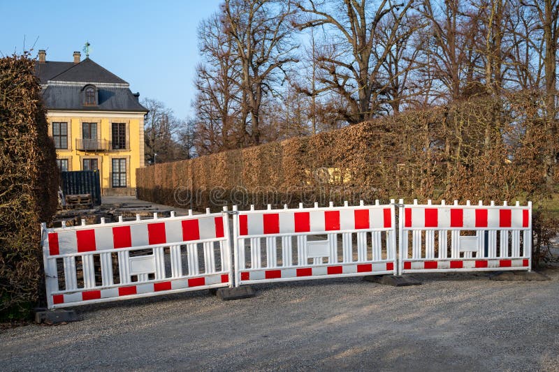 Red and White Construction Barriers Block a Pathway in a Park Stock ...