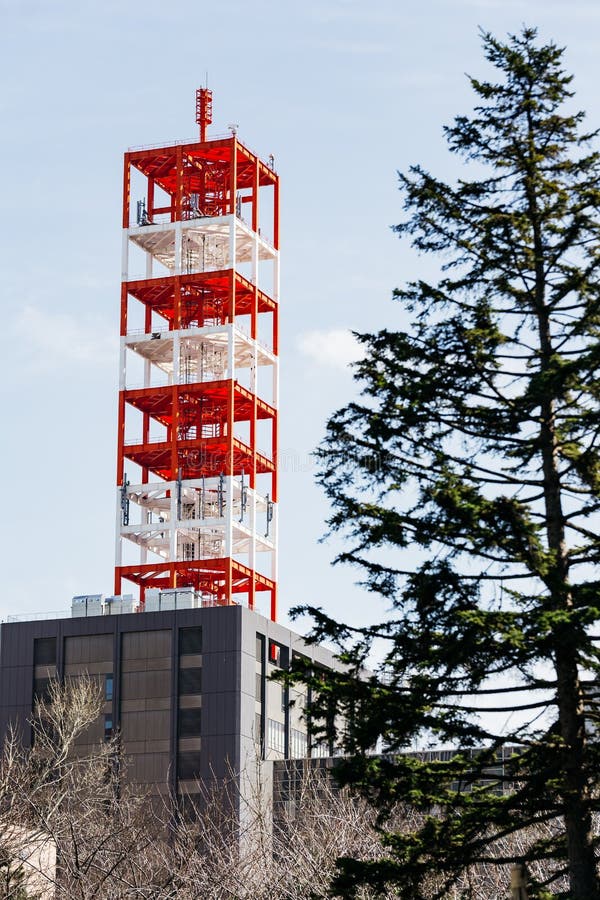 Red and White Construction Column Over the Building with Trees in the ...