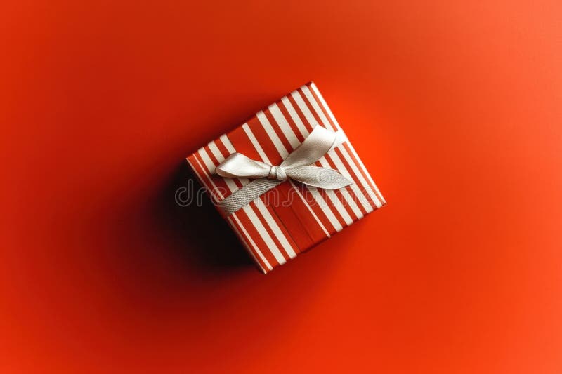 Red and White Gift Box with Ribbon on Bright Orange Background Stock ...