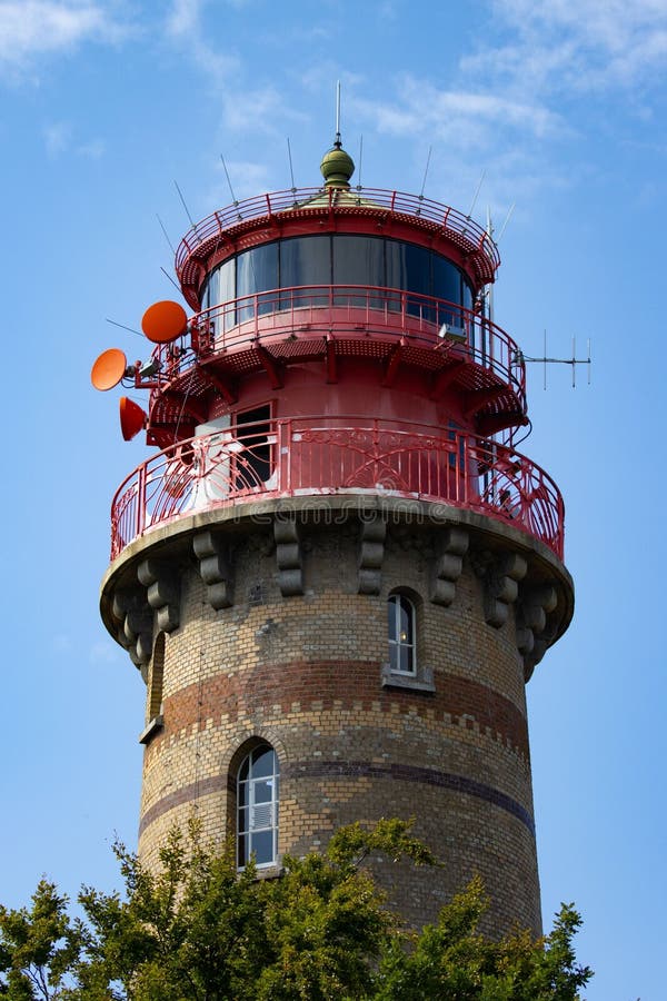 A Red and White Lighthouse is Above a Tree Filled Field Stock Photo ...