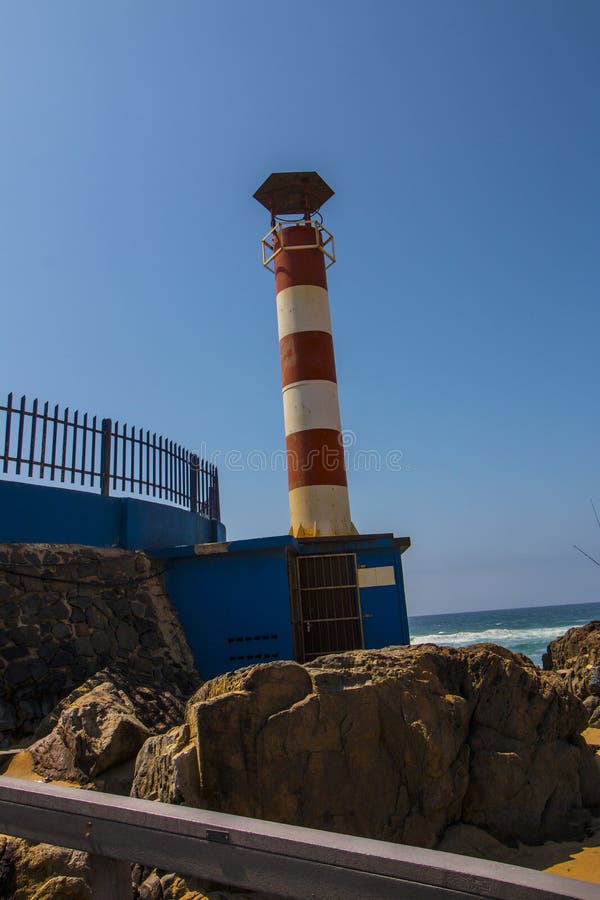 Red and White Lighthouse Built on Top of Rocks Stock Photo - Image of ...