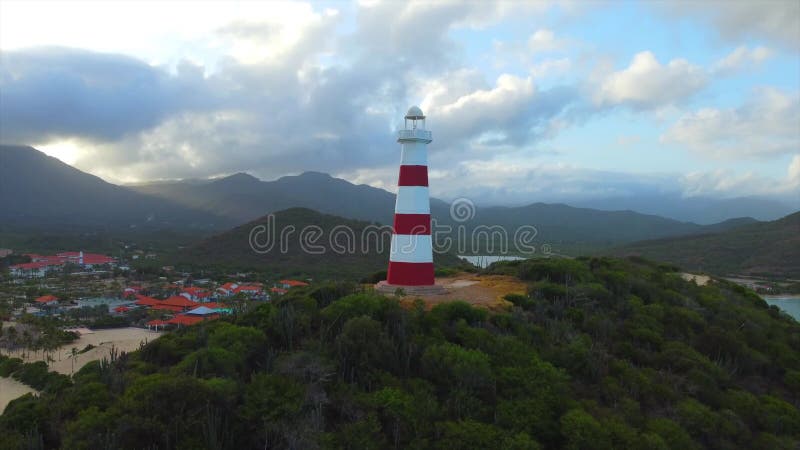 A Red and White Lighthouse is on a Hill Overlooking a Town Stock Video ...