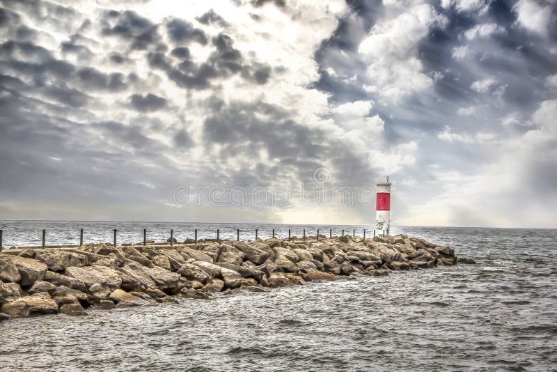 Red and White Lighthouse on a Jetty on an Ocean Stock Photo - Image of ...