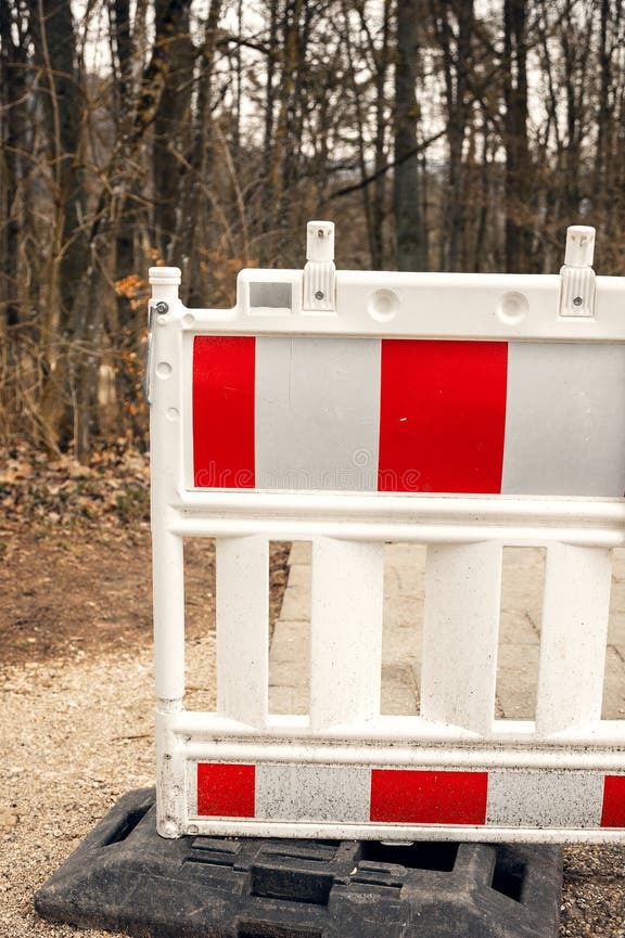 Red and White Road Barrier Blocking a Pathway in a Forest. Construction ...
