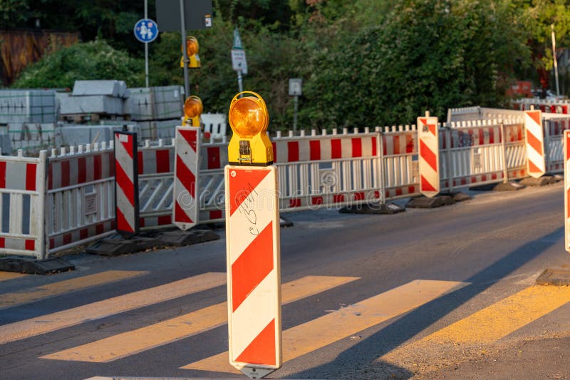 A Red and White Striped Pole with a Yellow and Red Sign on Top Stock ...