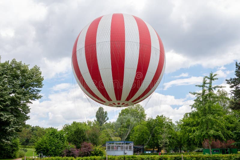 A Red and White Tethered Balloon in a Park among Green Trees. Stock ...