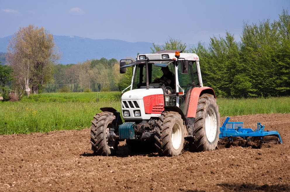 Red and White Tractor with Vibrocultor Working Fields Front Side Stock ...