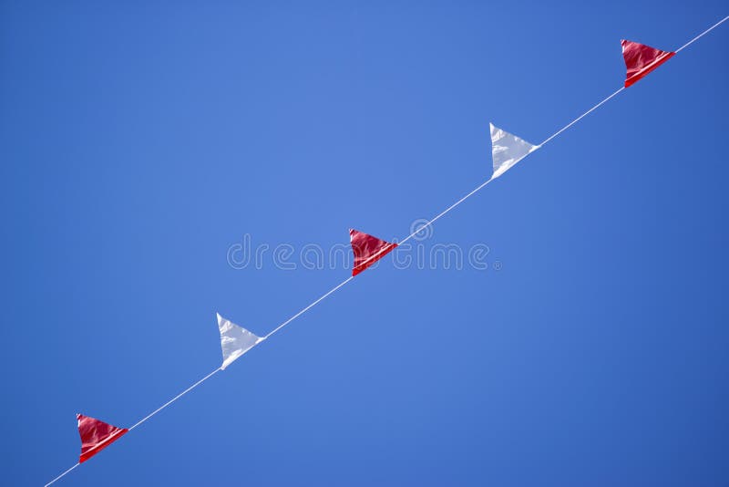 Red and White Triangular Flags on the Blue Sky Background Stock Photo ...