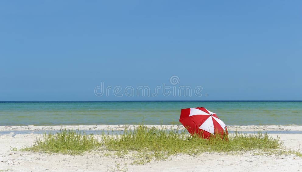 Red and White Umbrella on Beach Stock Photo - Image of beach, tranquil ...
