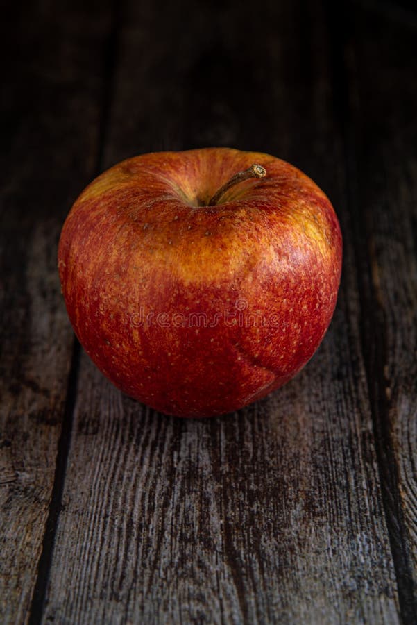Red Wilted Rotten Apple on a Wooden Surface Background Stock Photo ...