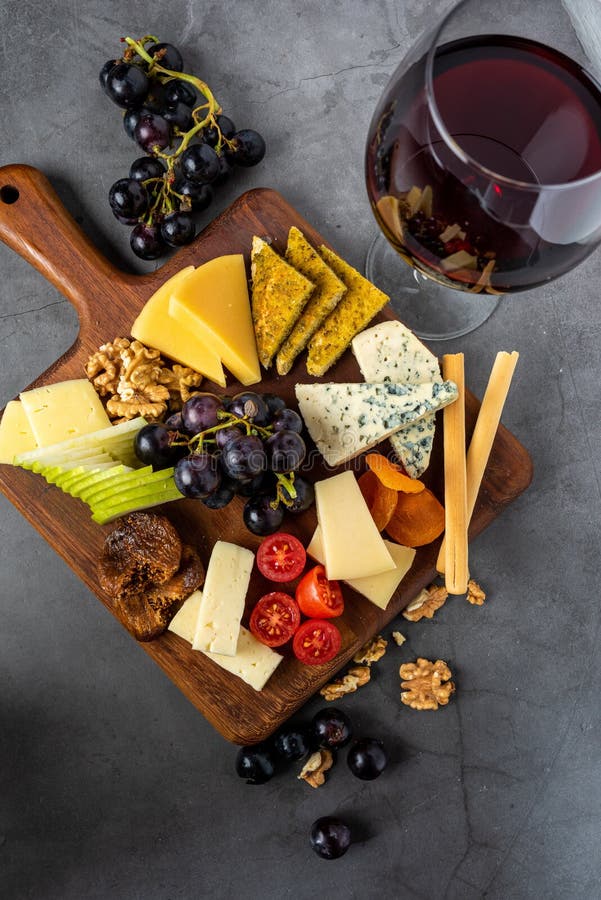 Red Wine and Assorted Cheese Plate with Fruit on Wooden Plate Stock ...