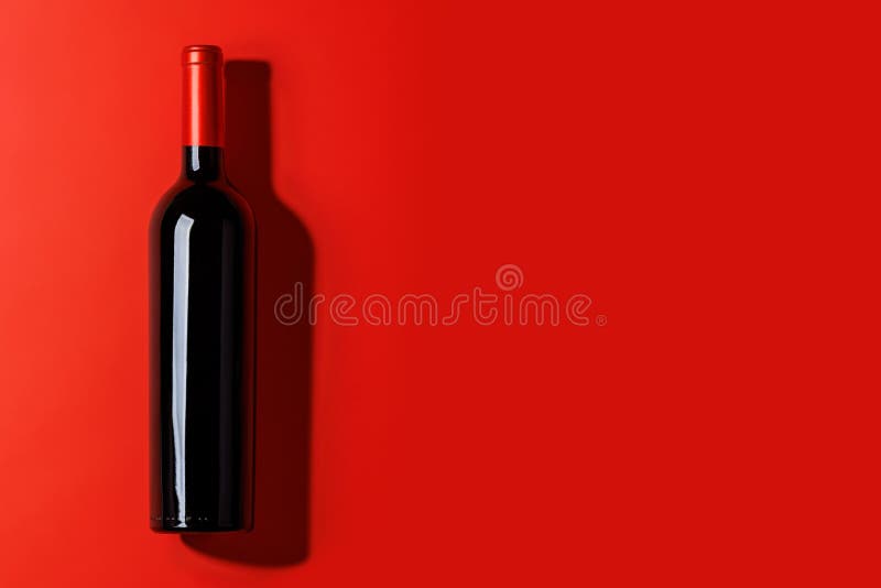 A Red Wine Bottle Lying Horizontally on a Bold Red Background Stock ...