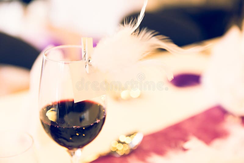 Red Wine Glass Feather Name Tag on Wedding Table Stock Photo - Image of ...