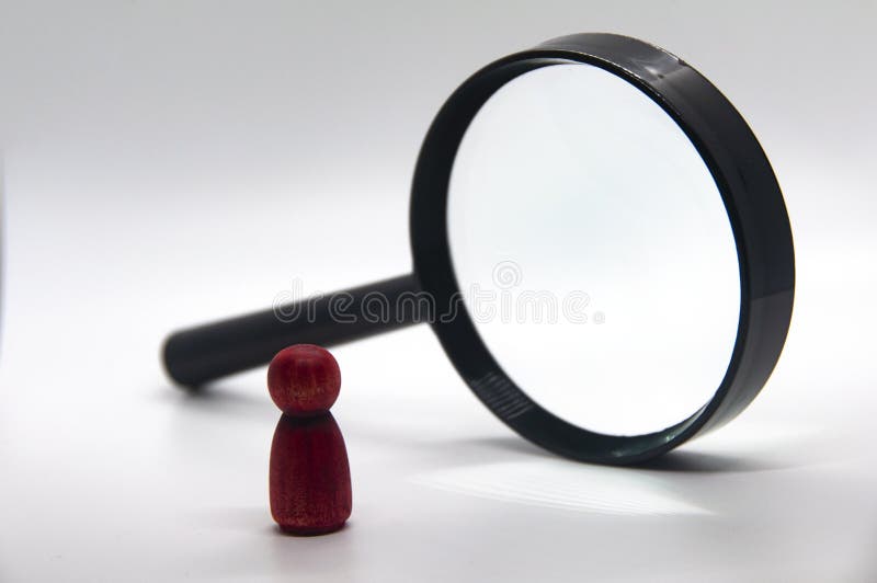Red Wooden Figure Looking through a Magnifying Glass with White ...