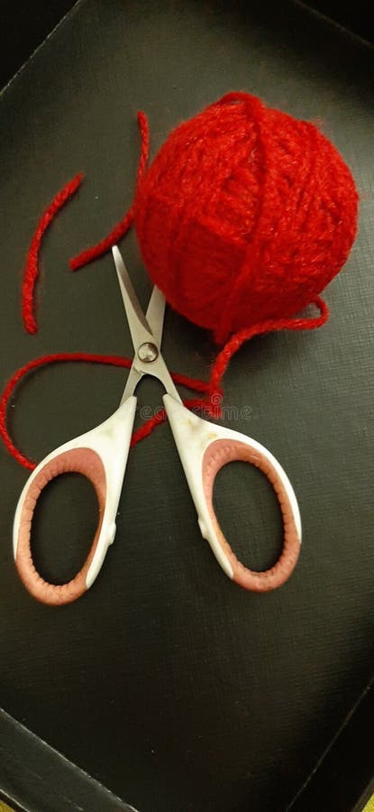 Red Woolen Ball, Scissor and Pieces of Wool on Black Background. Stock ...