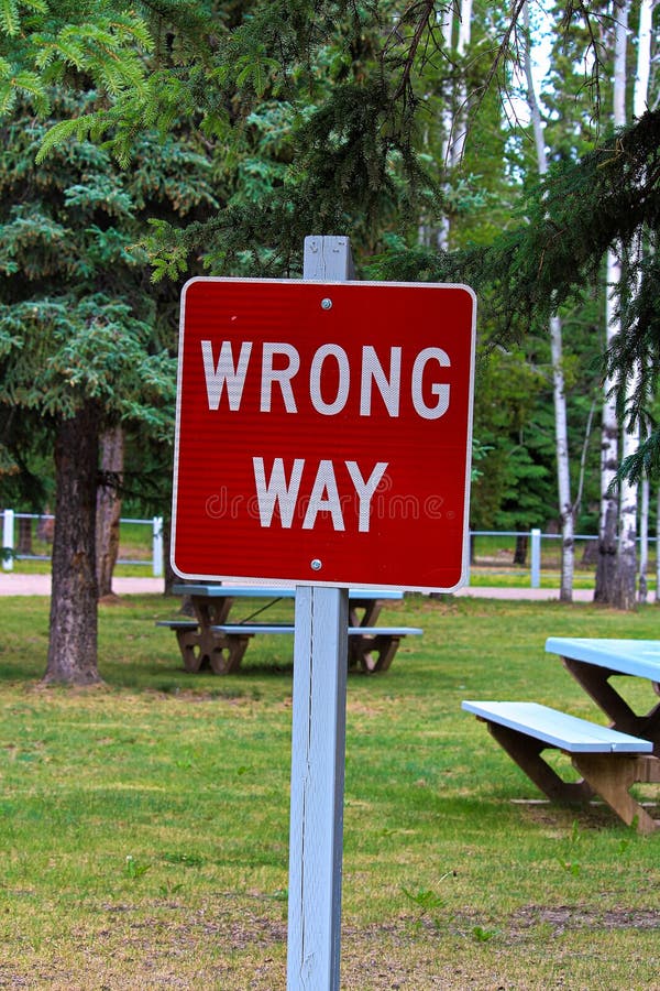 A Red Wrong Way Sign with Picnic Tables Behind it Stock Photo - Image ...