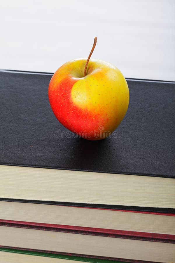 Red and Yellow Apple on Book Stack Stock Image - Image of apple ...