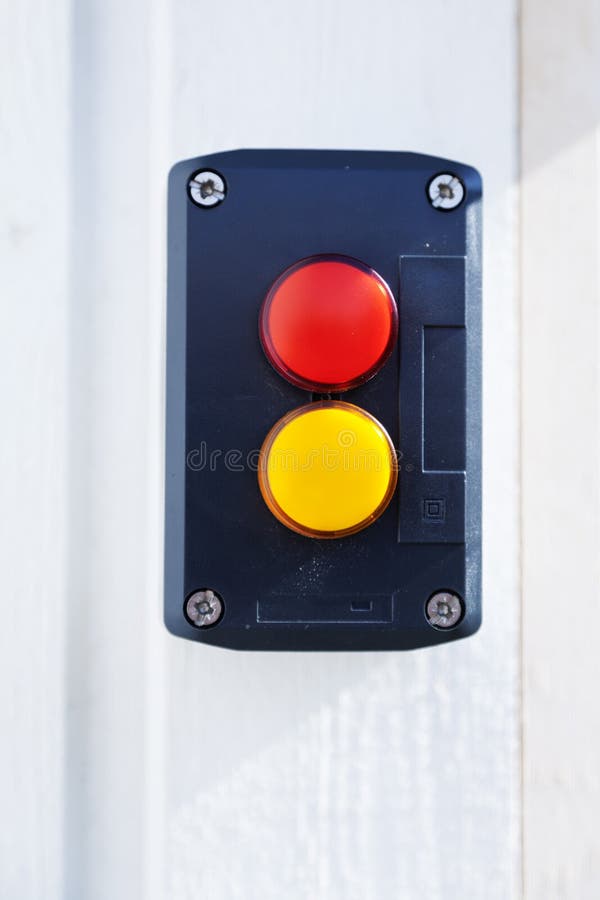 A Red and Yellow Button Mounted on the Wall Stock Photo - Image of ...
