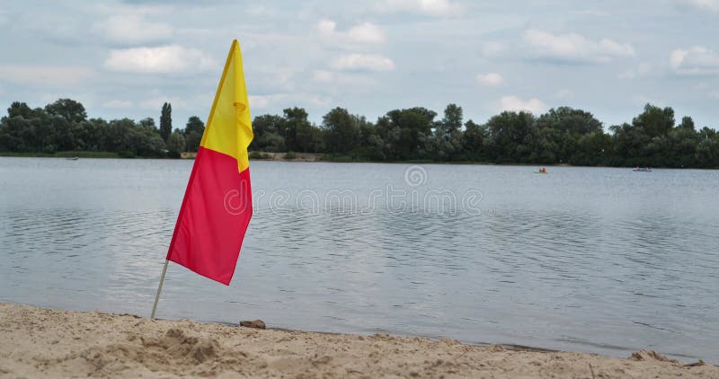 Red and Yellow Flag at the Bank of River Stock Footage - Video of ...