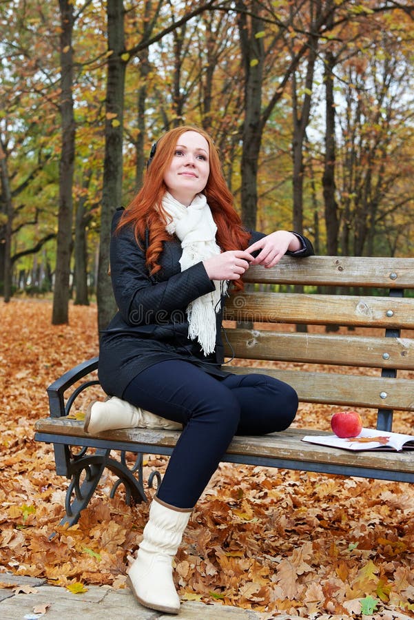 Redhead Girl With Headphones Listen Music On Player In City Park Fall