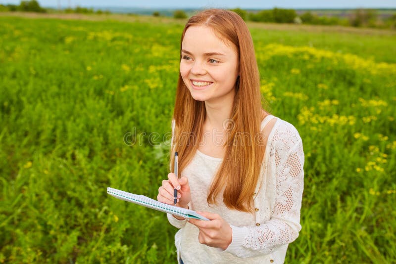 Girl with Pen Writing on Notebook on Grass Outside Stock Image - Image ...