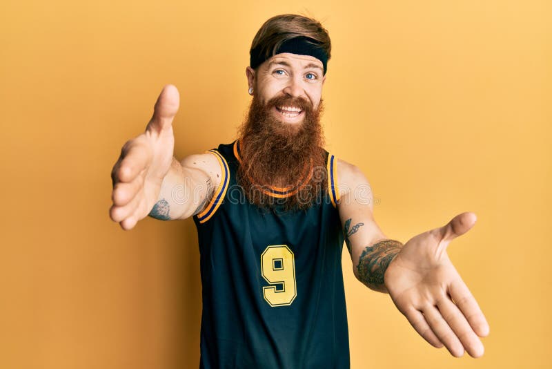 Redhead Man With Long Beard Wearing Basketball Uniform Looking At The
