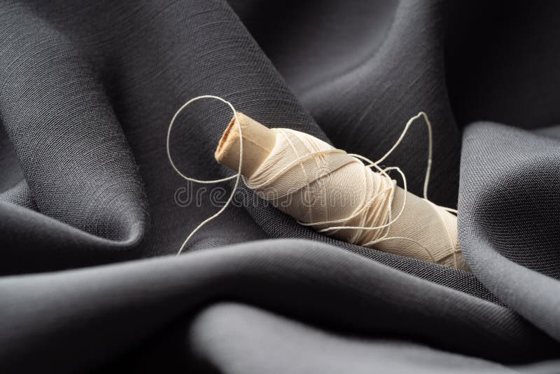 A Reel with White Threads in a Draped Soft Gray Fabric, Close-up, Macro ...