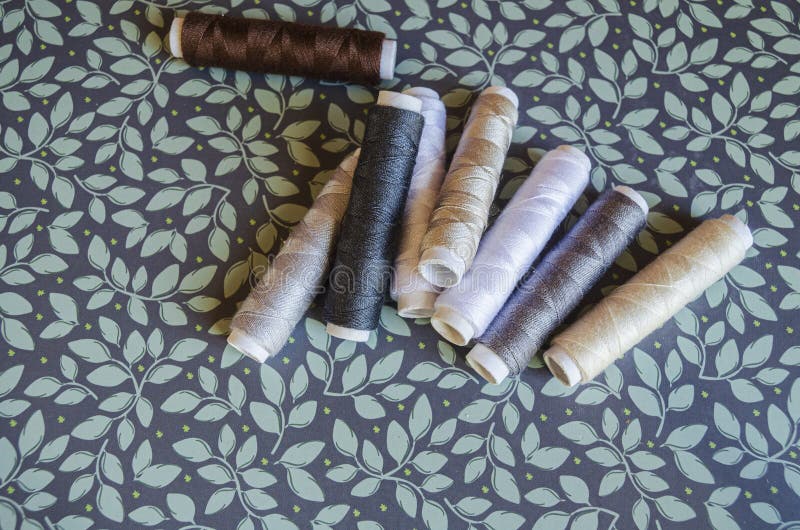 Reels of Different Coloured Thread on a Green Floral Background Stock ...