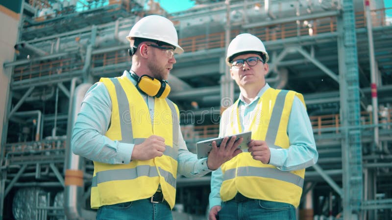 Refinery Co-workers Talking at a Modern Industrial Facility. Stock ...