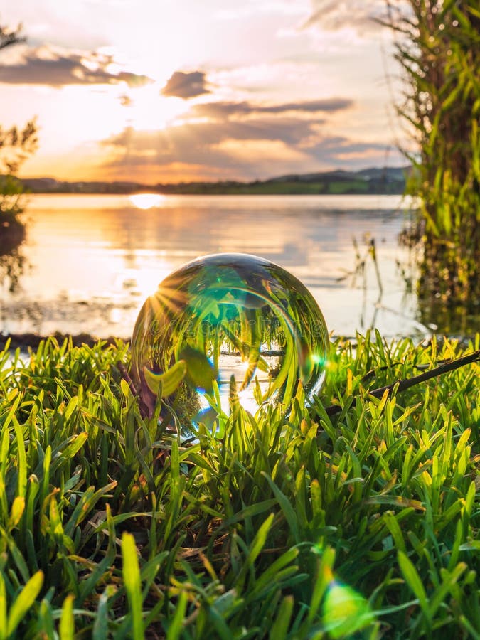 Reflecting Glass Ball on the Beach with Log Grass Under Sunset Sky ...